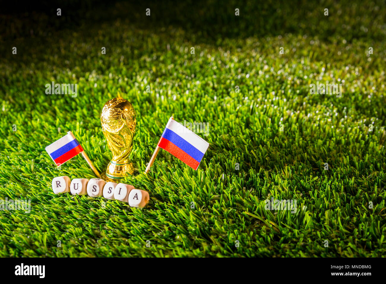 Fifa Cup concept. Golden trophy, russian flags over green grass with ...