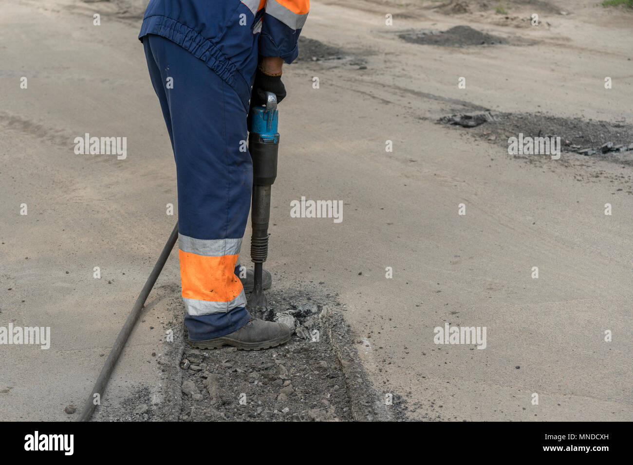 repair of roads. the worker is repairing the road Stock Photo - Alamy