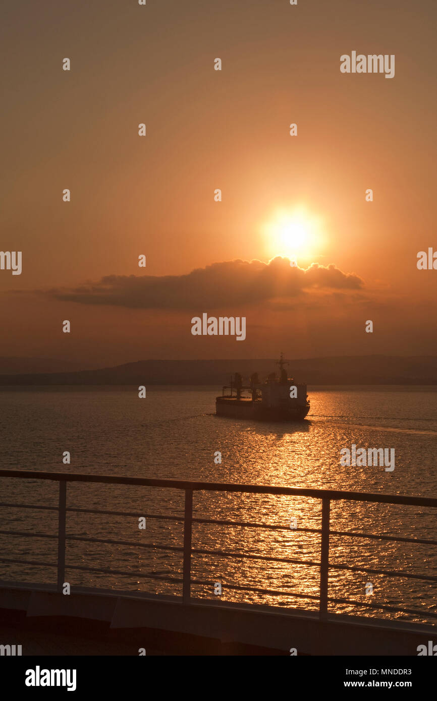 The beautiful sea at sunset with a cargo ship on the water, taken from ...