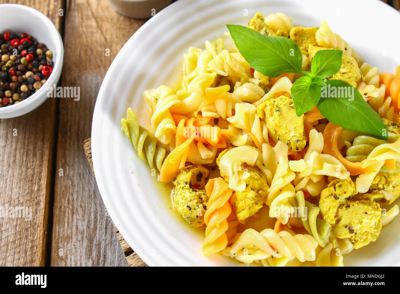 Pasta with slices of fried chicken fillet on an old wooden table Stock ...