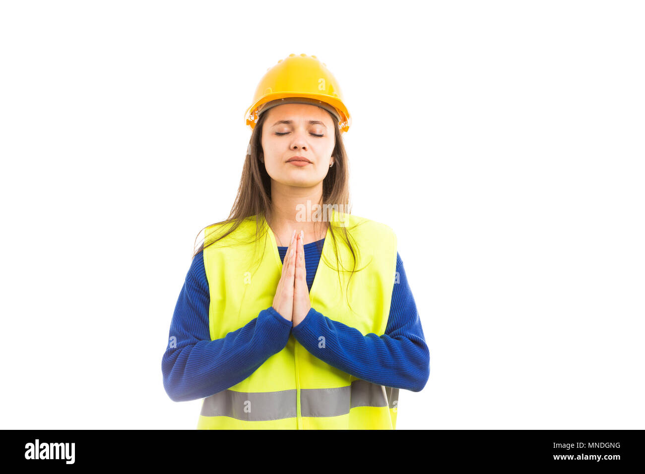 Young attractive woman architect or engineer praying with hands ...