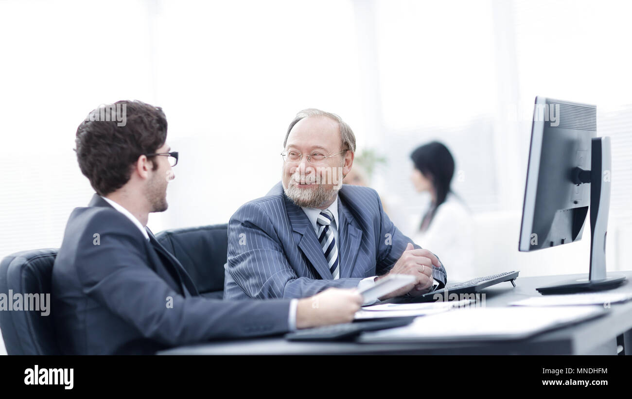 two businessmen discussing work issues sitting at their Desk Stock ...