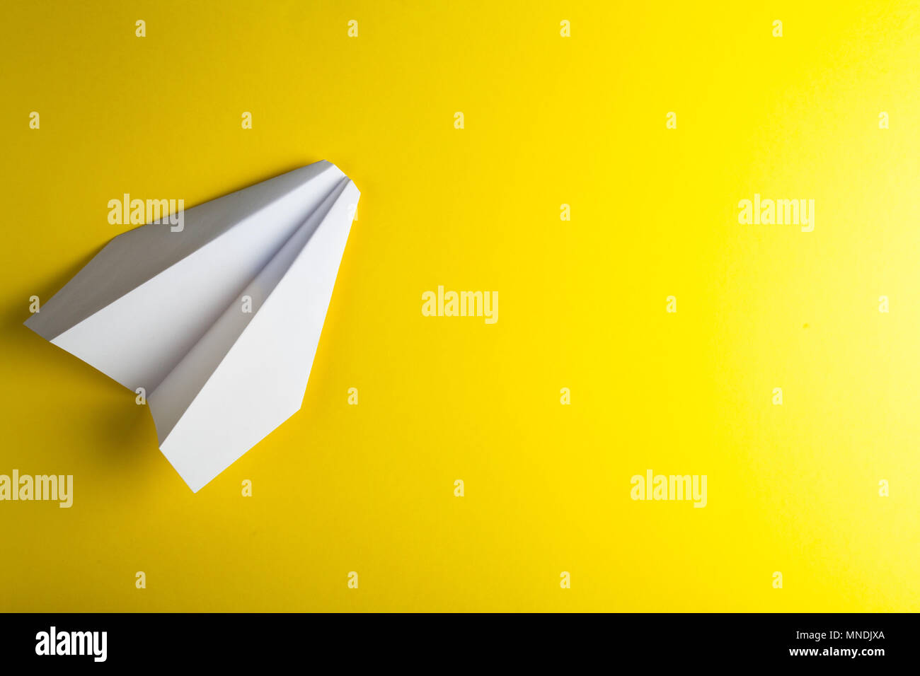 paper airplane on yellow background Stock Photo - Alamy