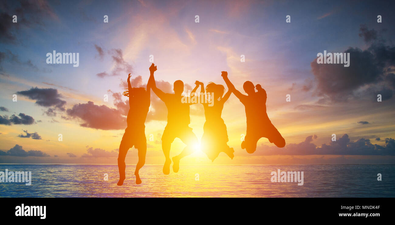 Silhouette of happy business team making high hands in sunset sky ...