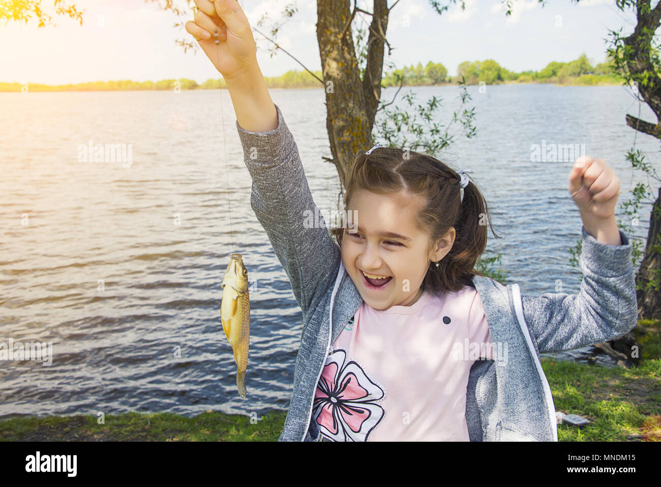 girl holding a fish caught in her hand ,rejoicing and smiling Stock ...