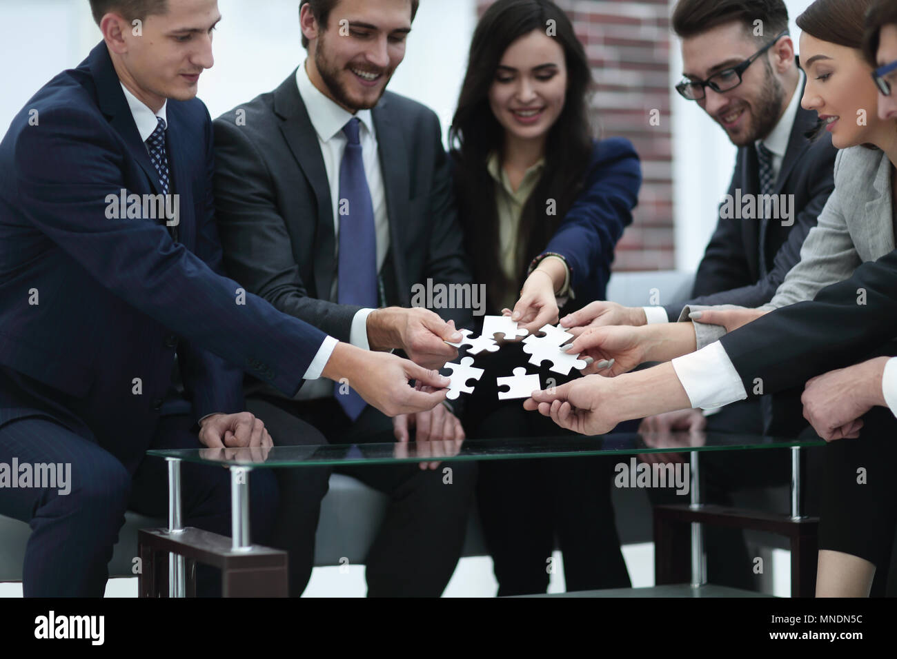 Business team solving puzzle together Stock Photo - Alamy