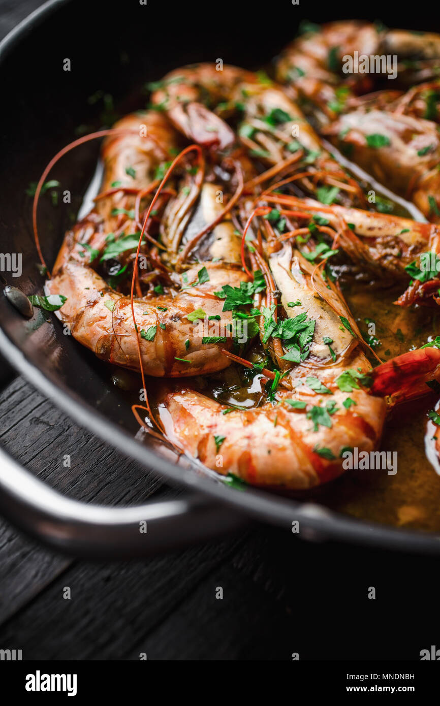 Tiger shrimps fried in a pan. Classic recipe - parsley, garlic, chilli ...