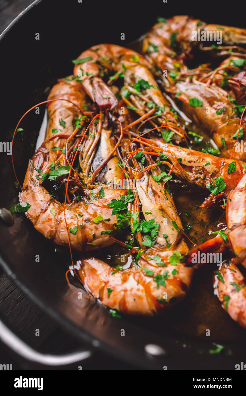 Tiger shrimps fried in a pan. Classic recipe - parsley, garlic, chilli ...