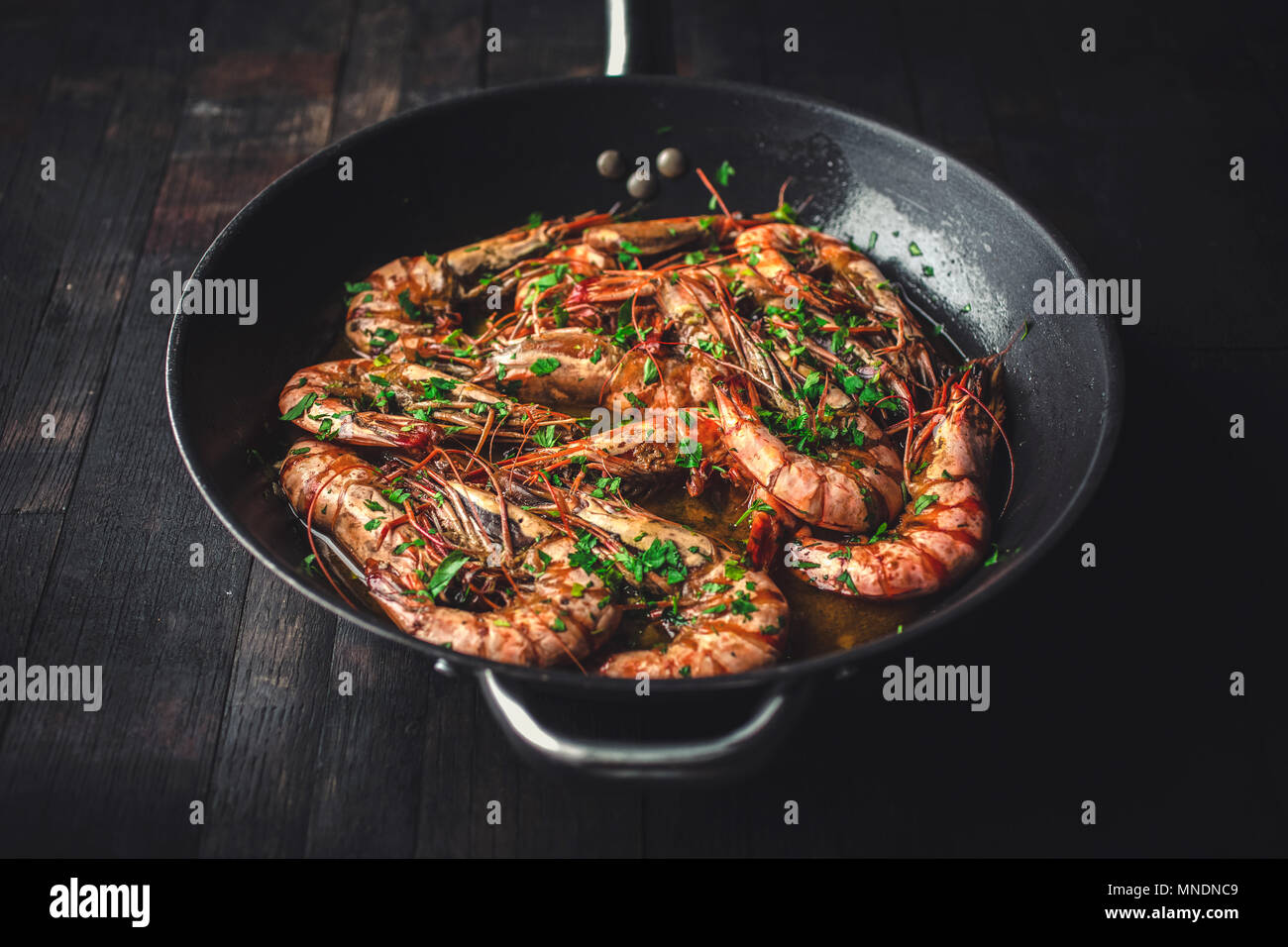 Tiger shrimps fried in a pan. Classic recipe - parsley, garlic, chilli ...