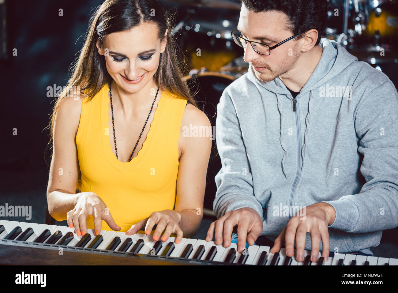 Piano players playing together four-handed Stock Photo - Alamy