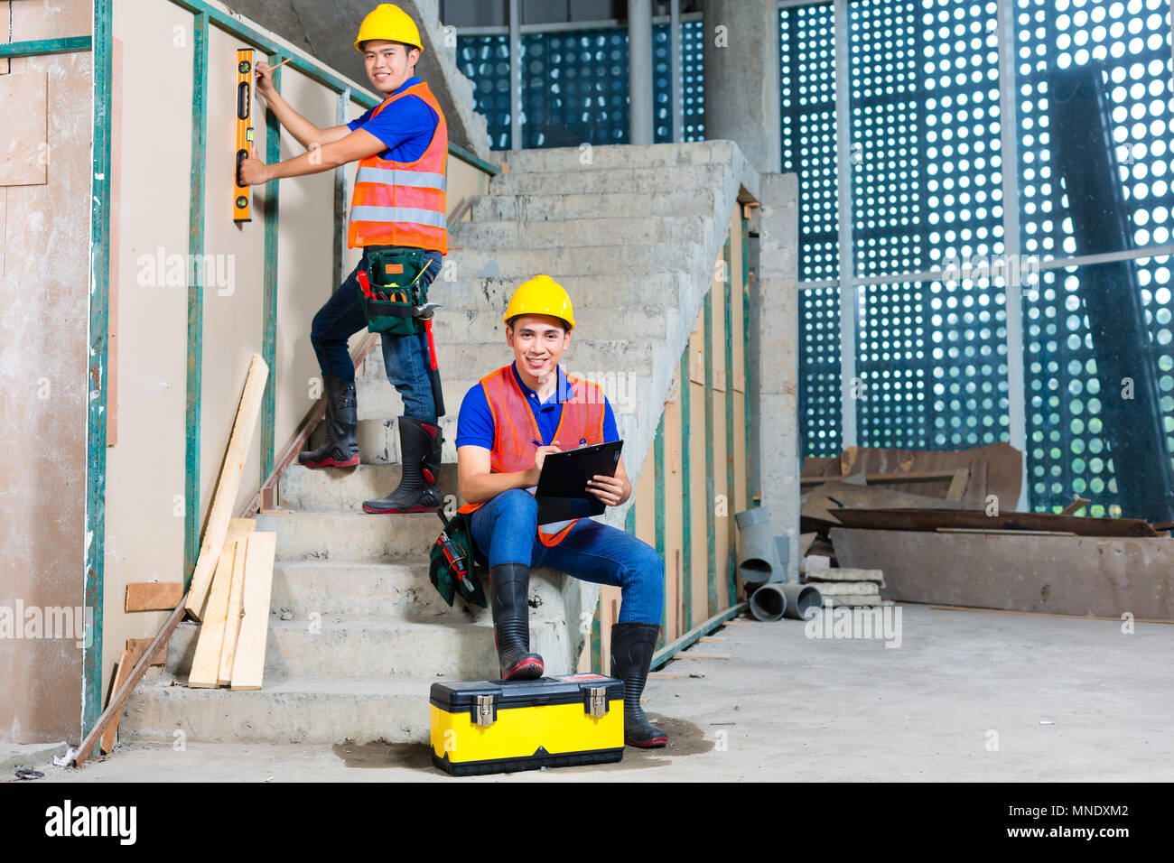Asian workers on building or construction site walling Stock Photo - Alamy