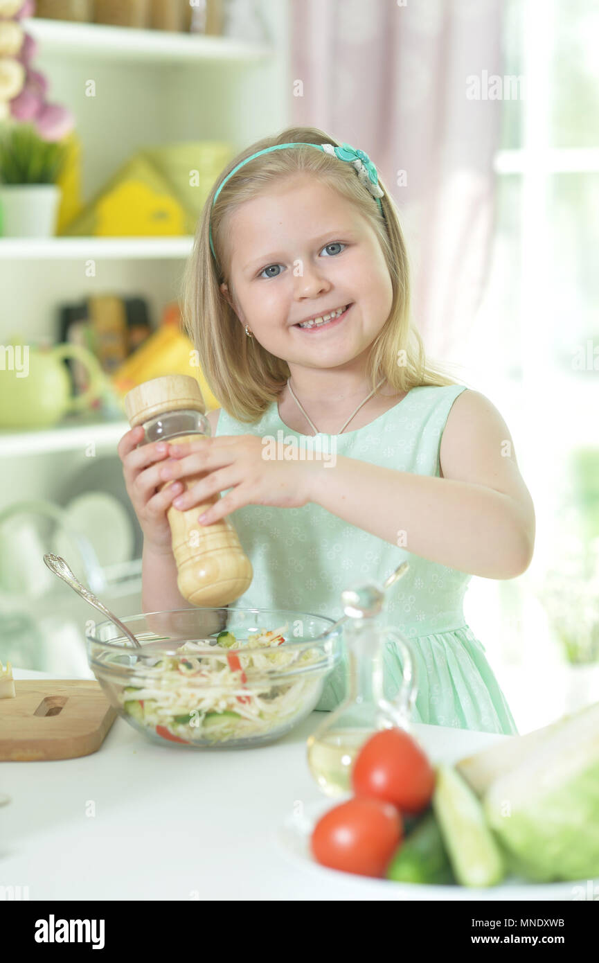 Cute little girl making dinner Stock Photo - Alamy