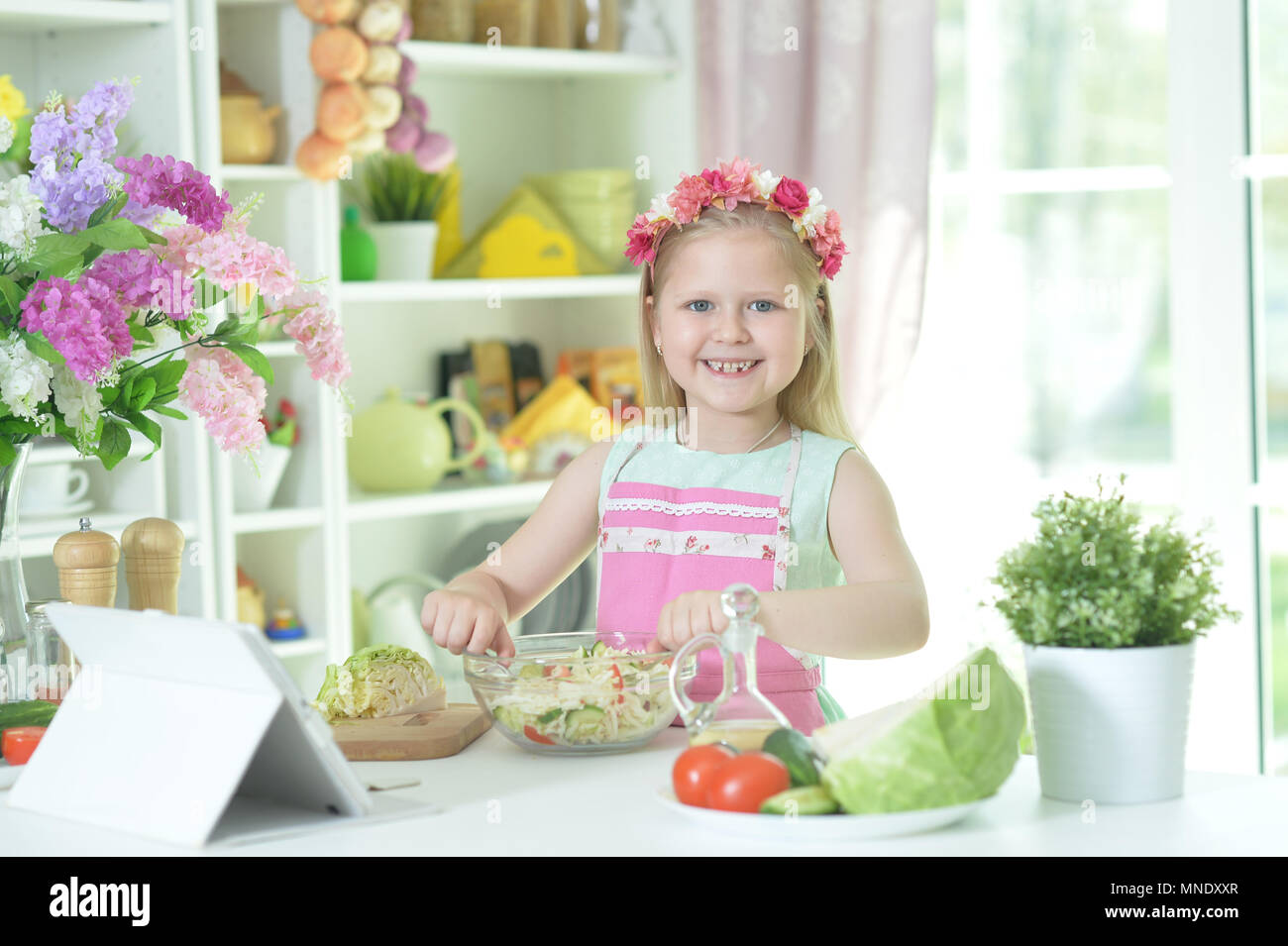 Cute little girl making dinner Stock Photo - Alamy