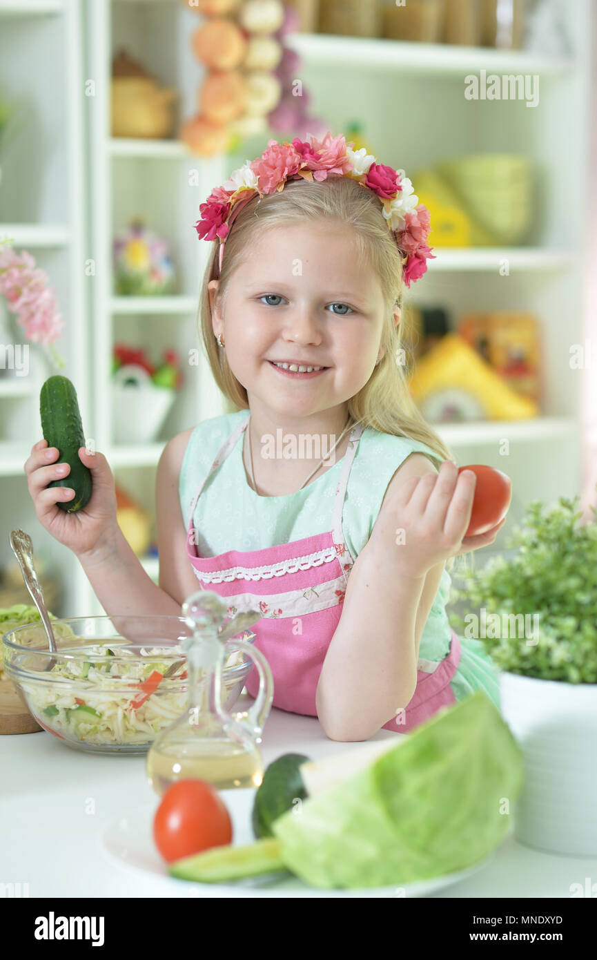 Cute little girl making dinner Stock Photo - Alamy