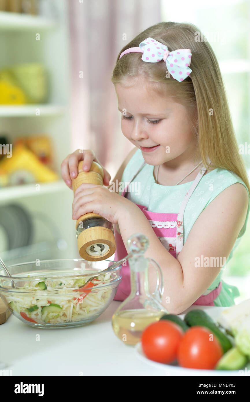 Cute little girl making dinner Stock Photo - Alamy