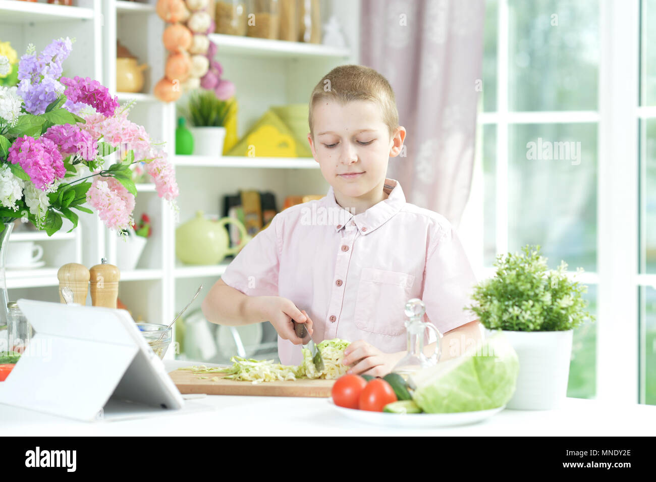 Cute little boy making dinner Stock Photo - Alamy