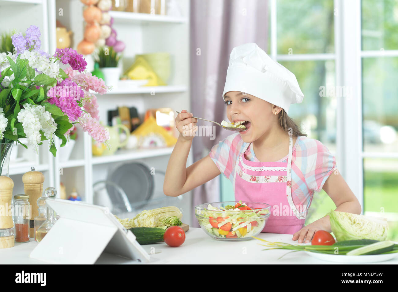 Cute little girl making dinner Stock Photo - Alamy