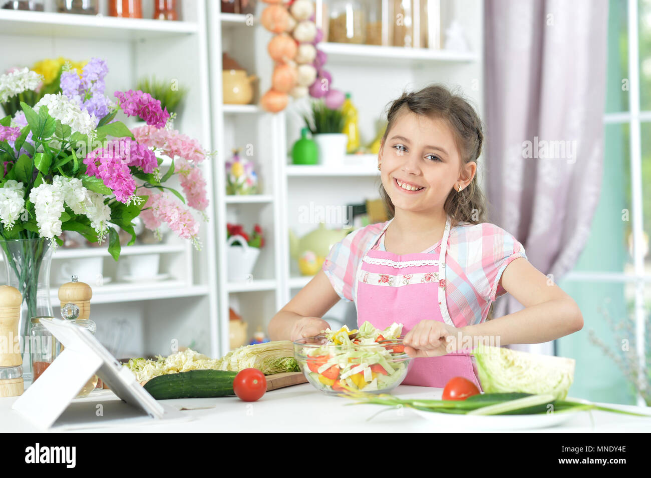 Cute little girl making dinner Stock Photo - Alamy