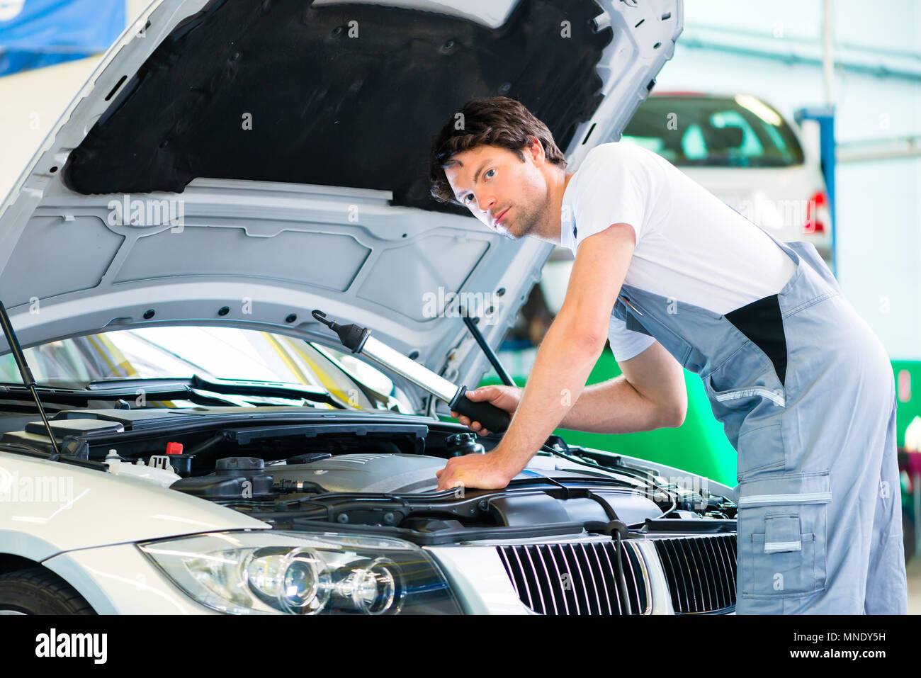 Mechanic repairing automobile motor hi-res stock photography and images ...
