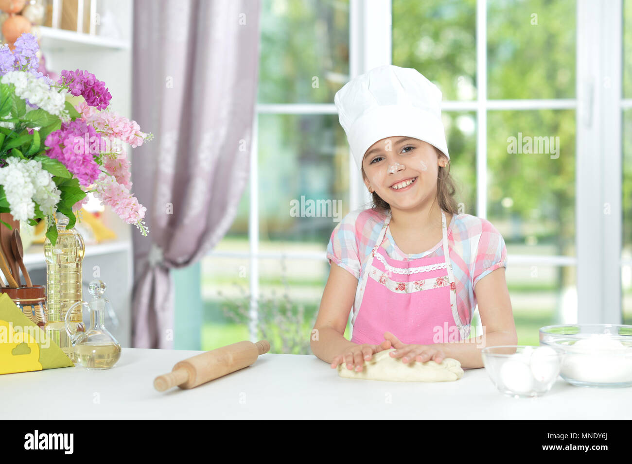 Cute little girl making dinner Stock Photo - Alamy