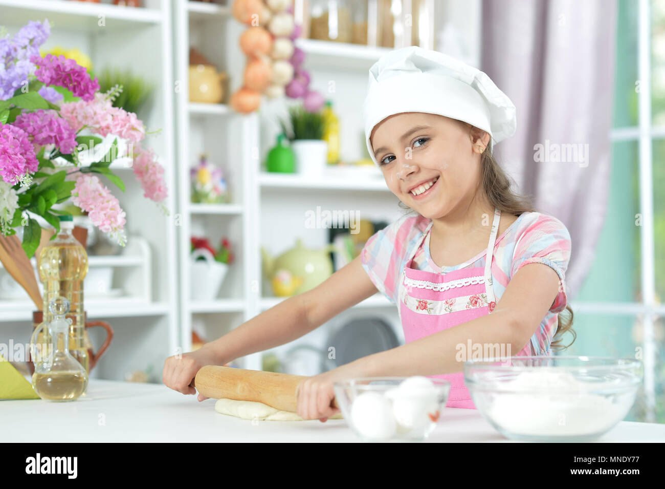 Cute little girl making dinner Stock Photo - Alamy