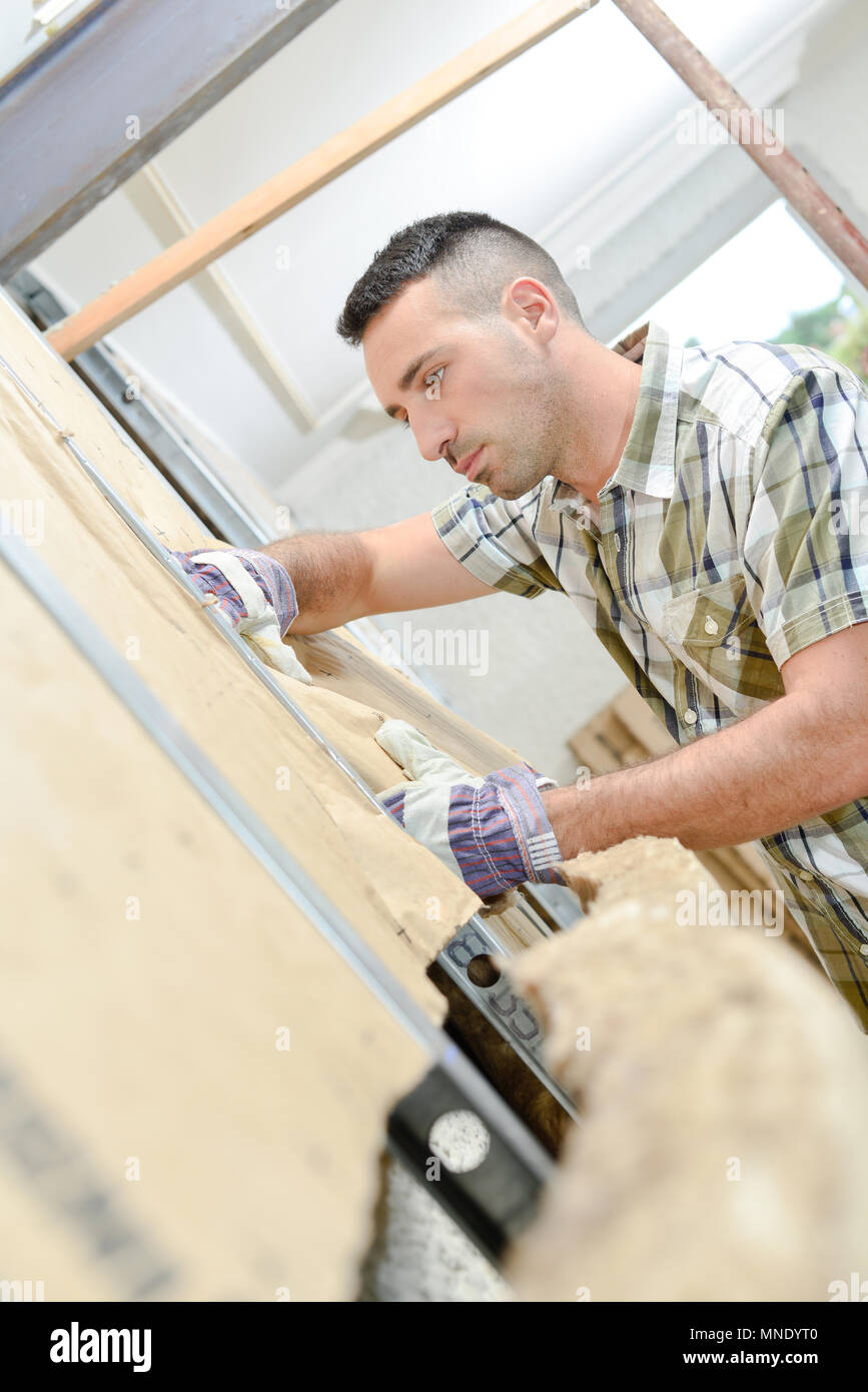 Builder fitting insulation to walls Stock Photo - Alamy