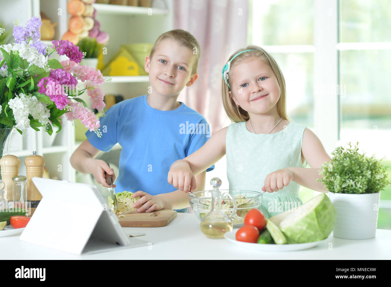 Cute little brother and sister cooking together at kitchen Stock Photo ...