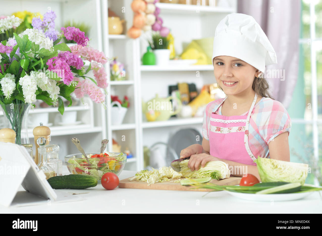 Cute little girl making dinner on kitchen table at home Stock Photo - Alamy