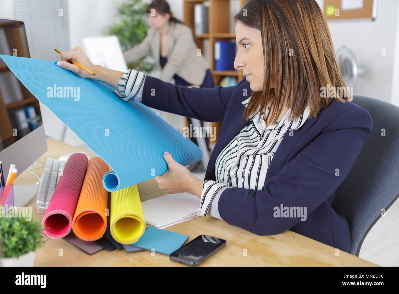 designer unrolling and checking a blue rolled paper Stock Photo - Alamy