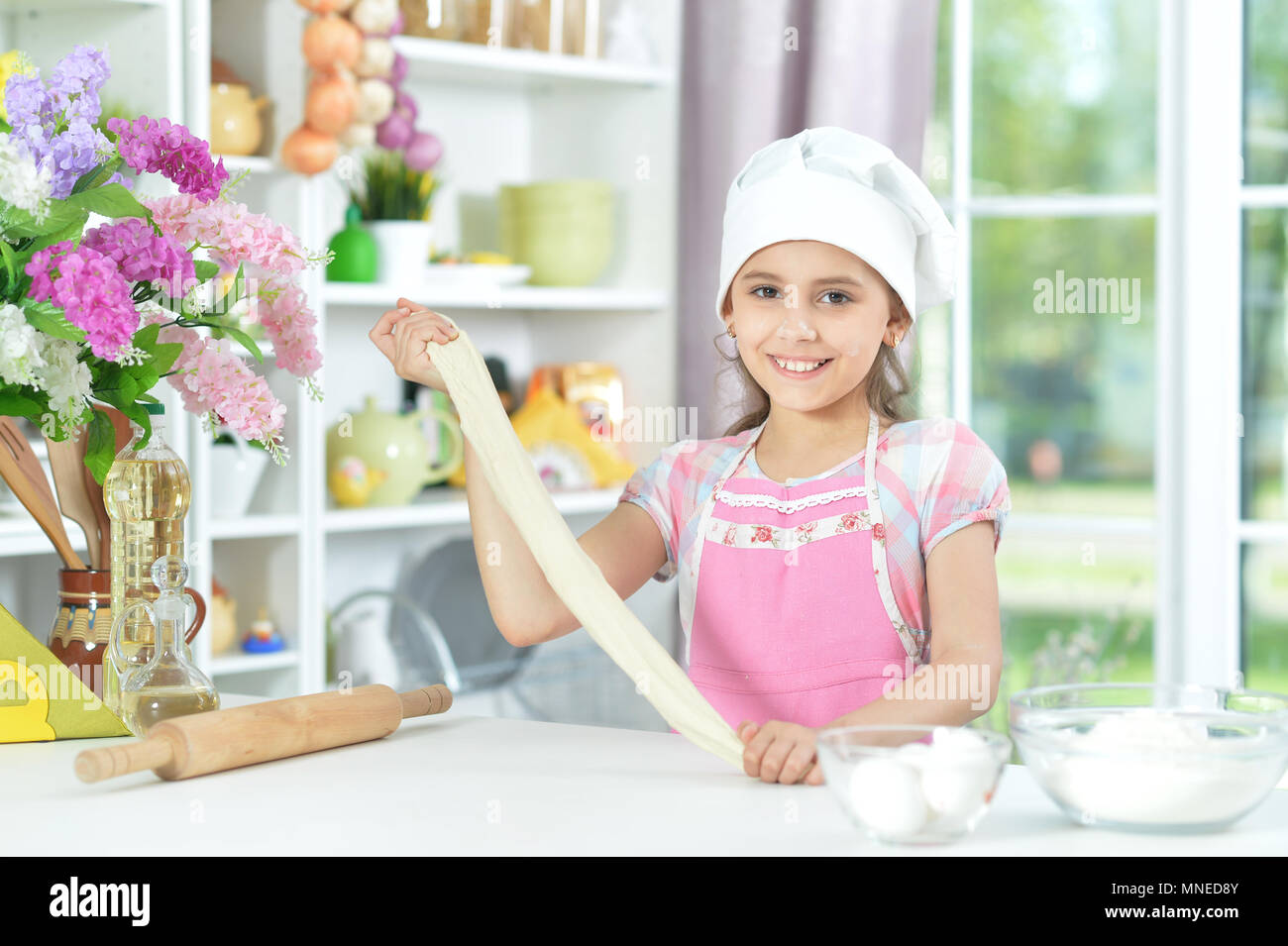 Cute little girl making dinner on kitchen table at home Stock Photo - Alamy