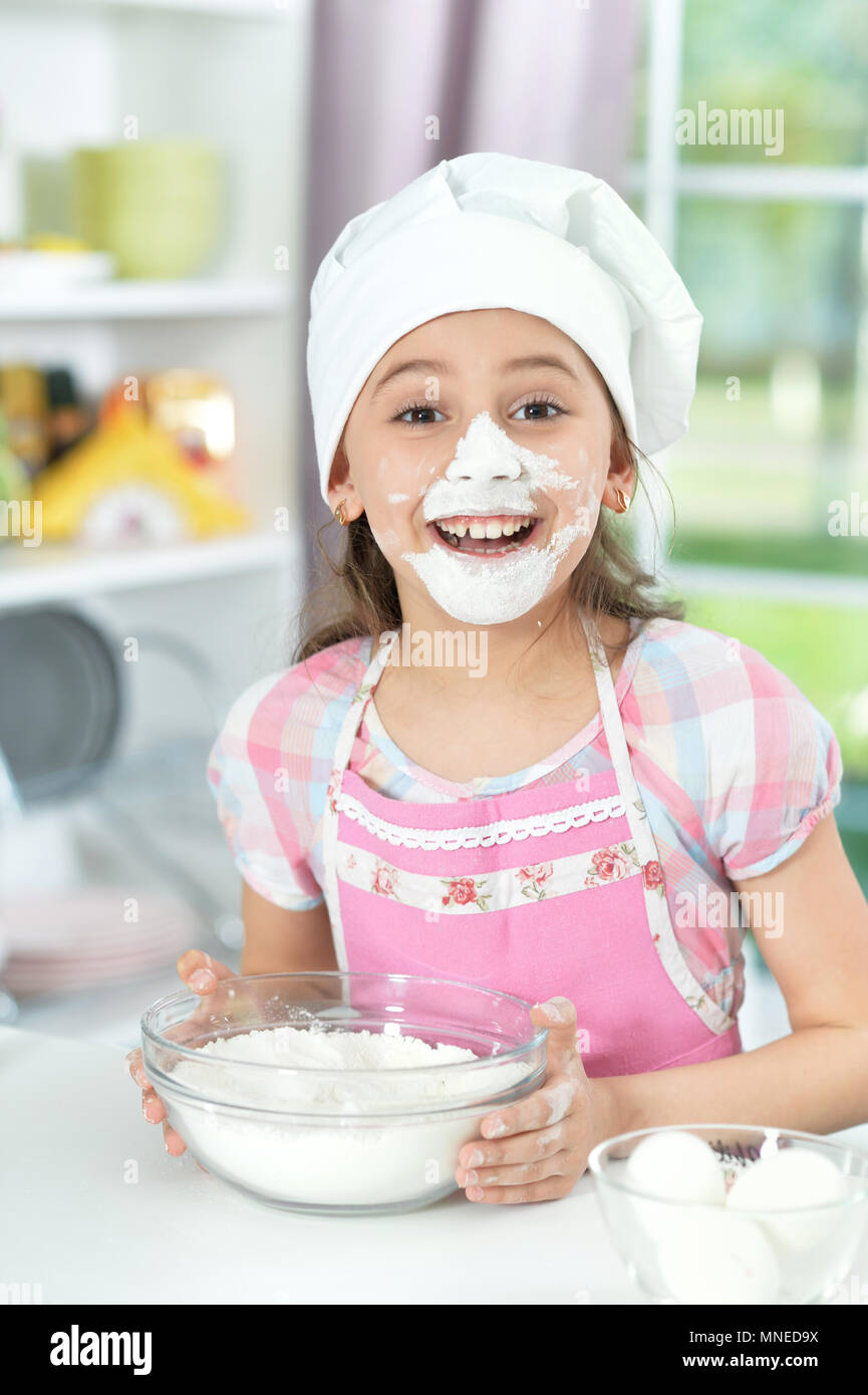 Cute little girl making dinner Stock Photo - Alamy