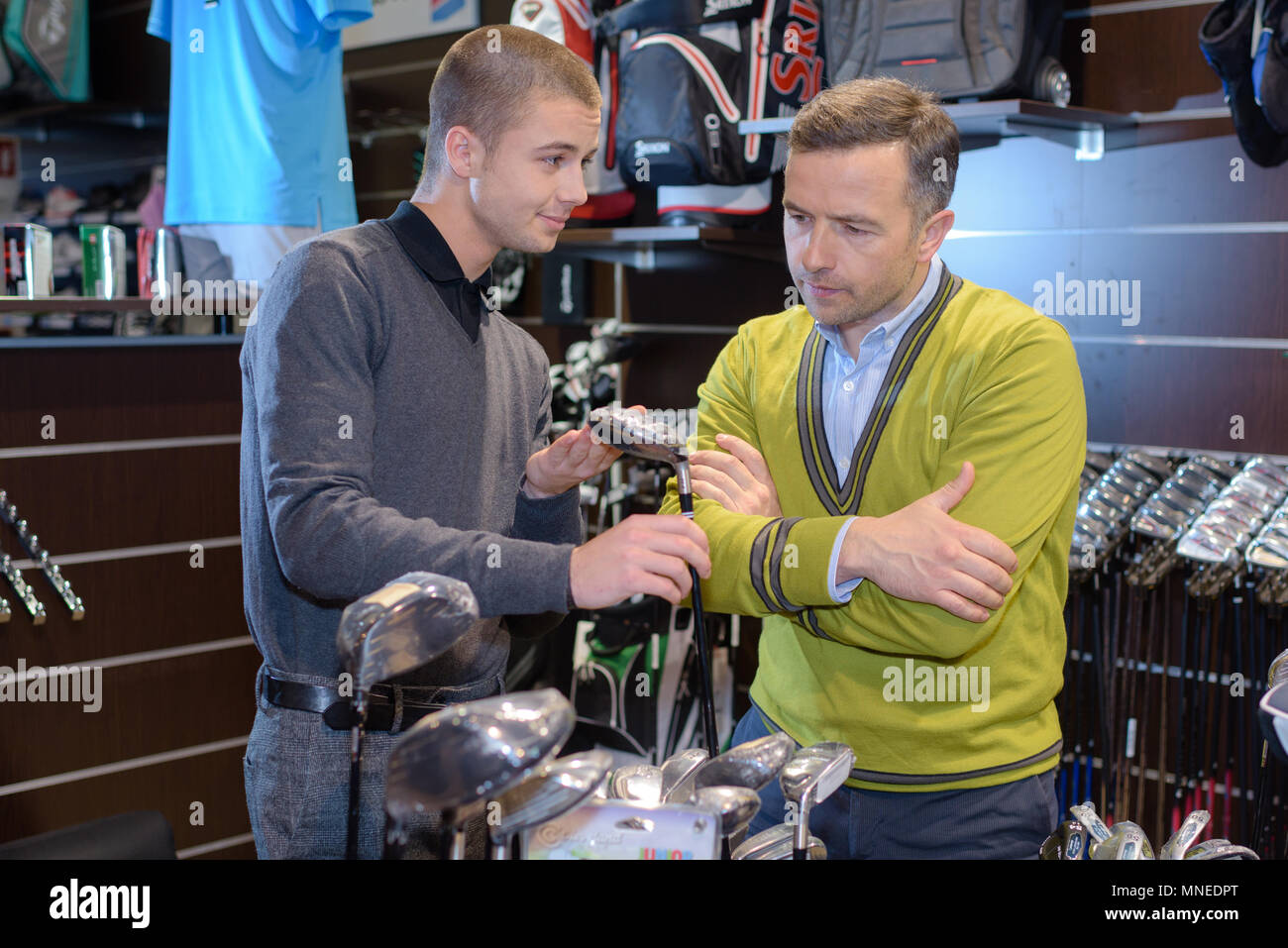 shop assistant holding a club at a golf shop Stock Photo - Alamy