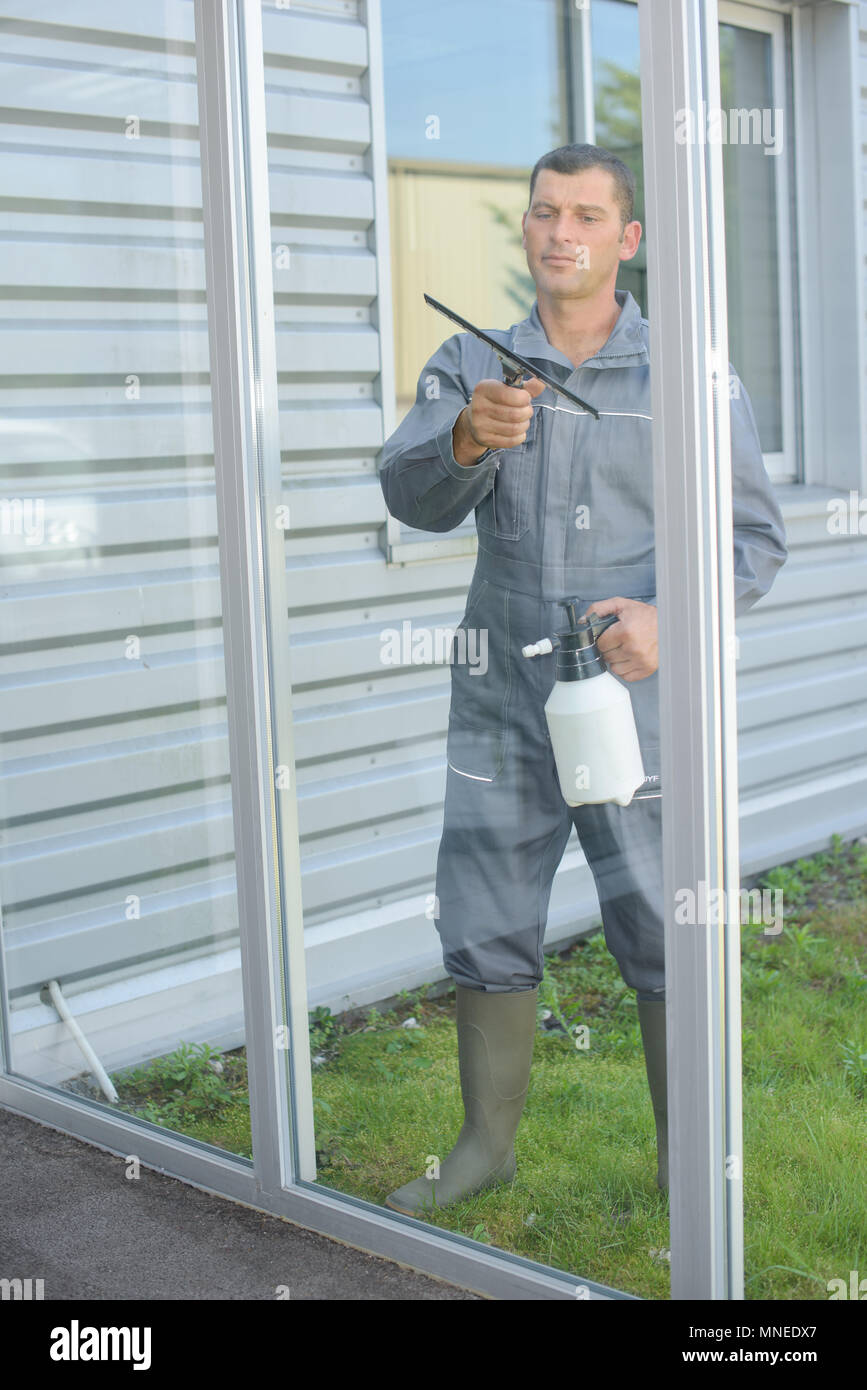 man cleaning windows with squeegee Stock Photo - Alamy