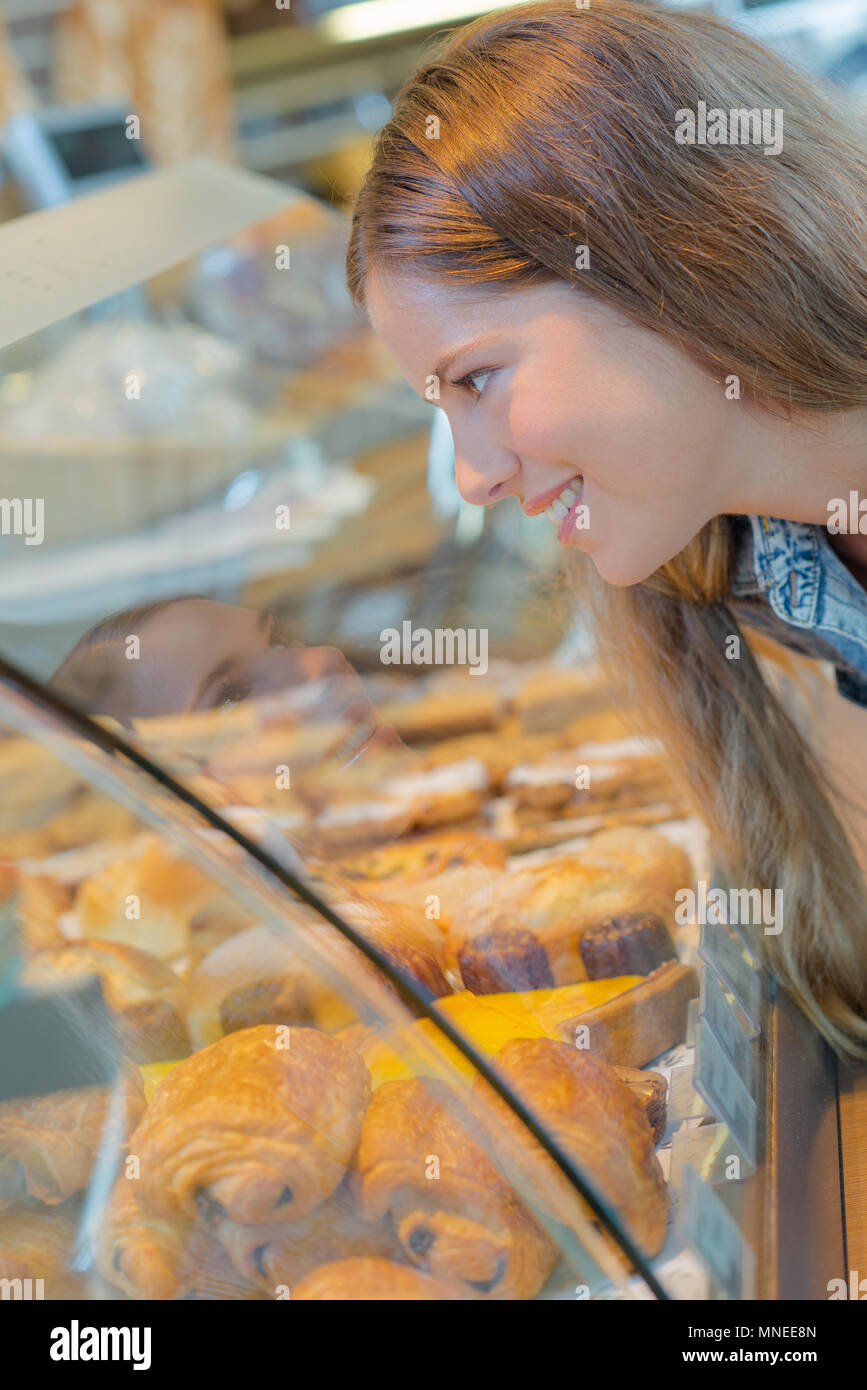 Lady looking into counter in bakers Stock Photo - Alamy