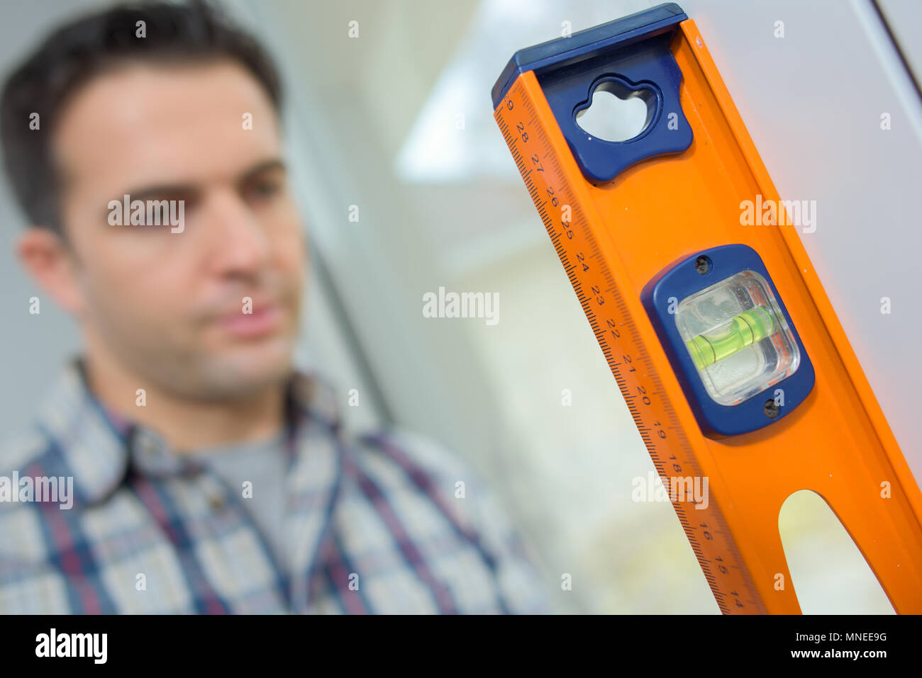 close up of a young handyman using a spirit level Stock Photo - Alamy