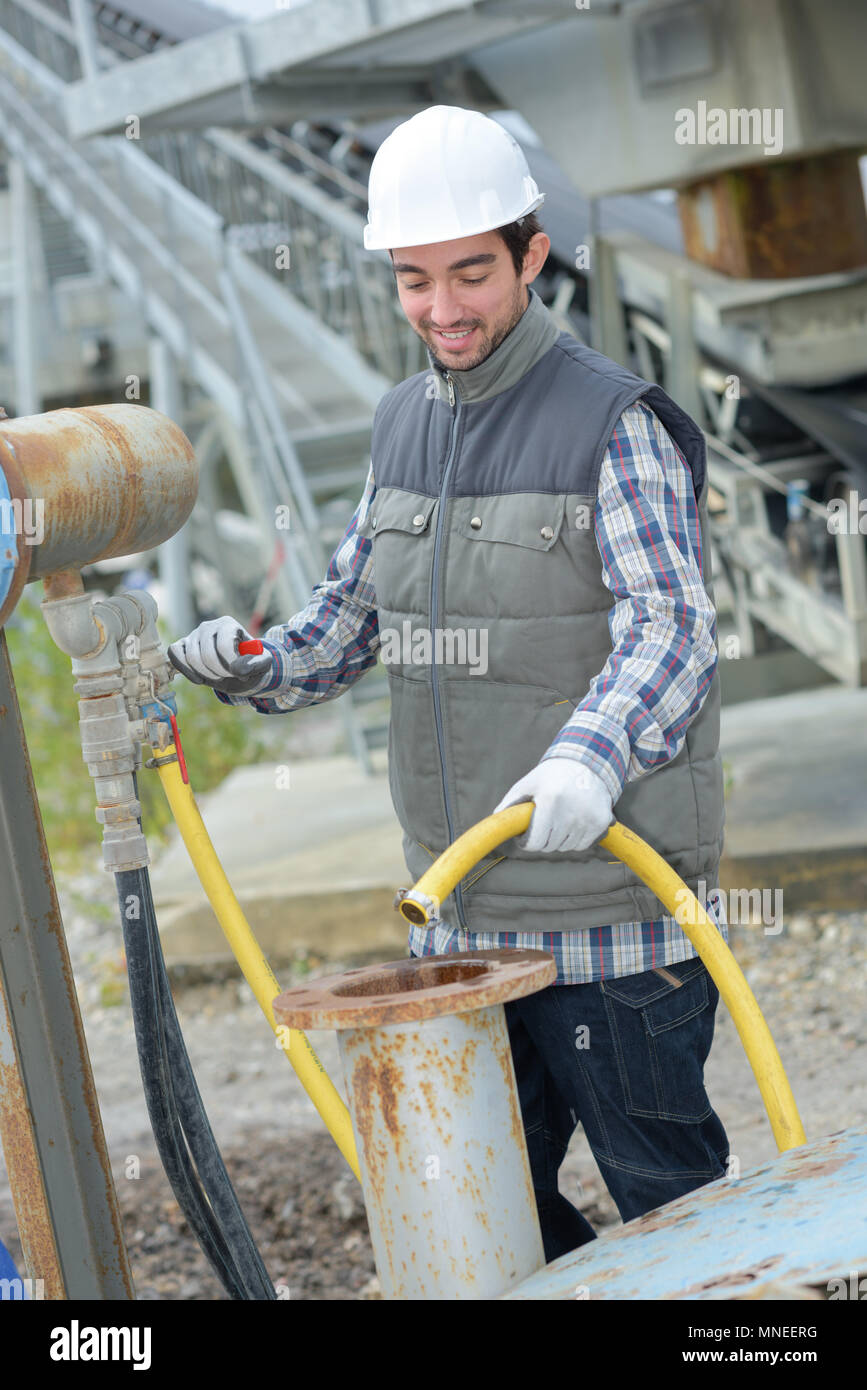 Man using hosepipe Stock Photo - Alamy