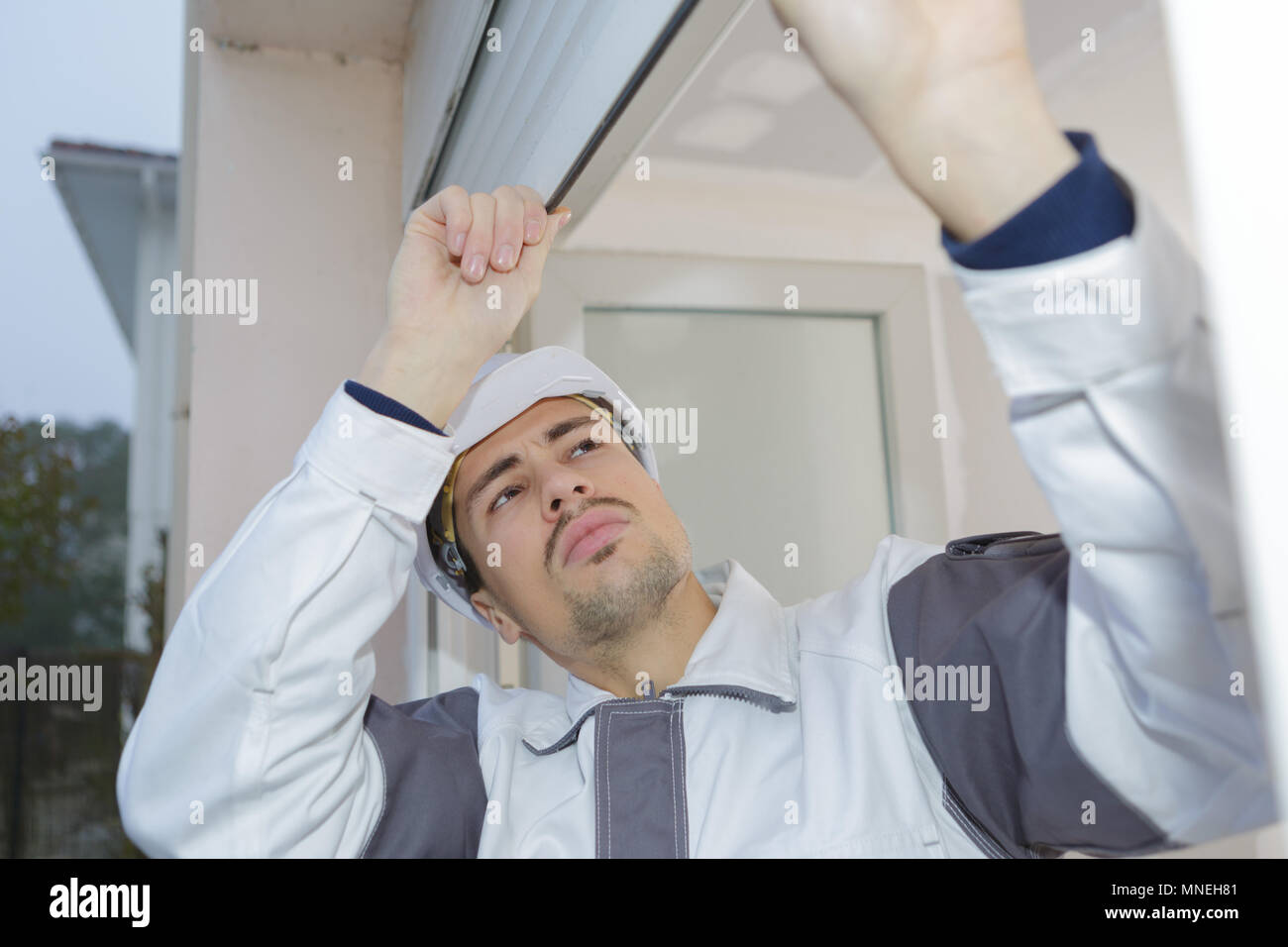 worker fitting pvc window with shutter Stock Photo - Alamy