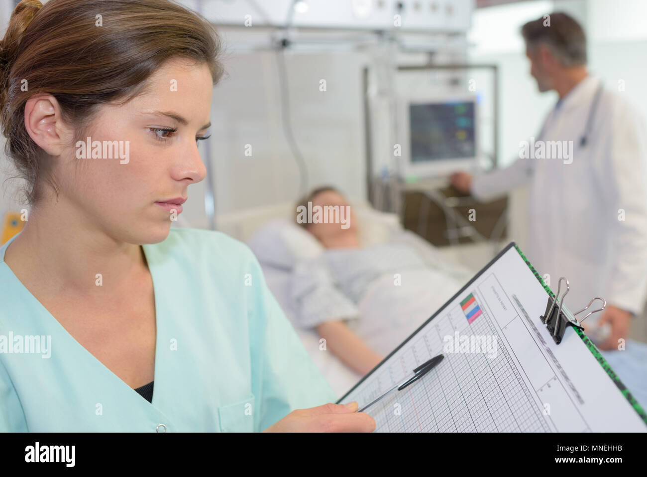 Nurse looking at chart on clipboard Stock Photo - Alamy