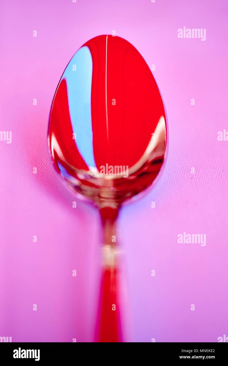 A red spoon on a pink surface Stock Photo - Alamy