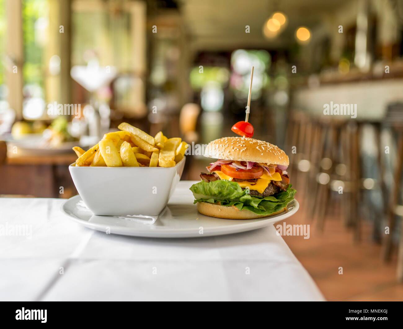 A cheeseburger with chips in a restaurant Stock Photo - Alamy