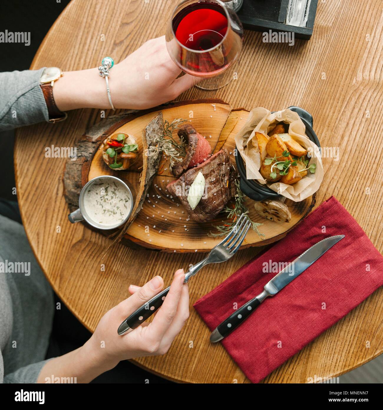 A woman eating steak with roasted potatoes and mushroom sauce Stock ...