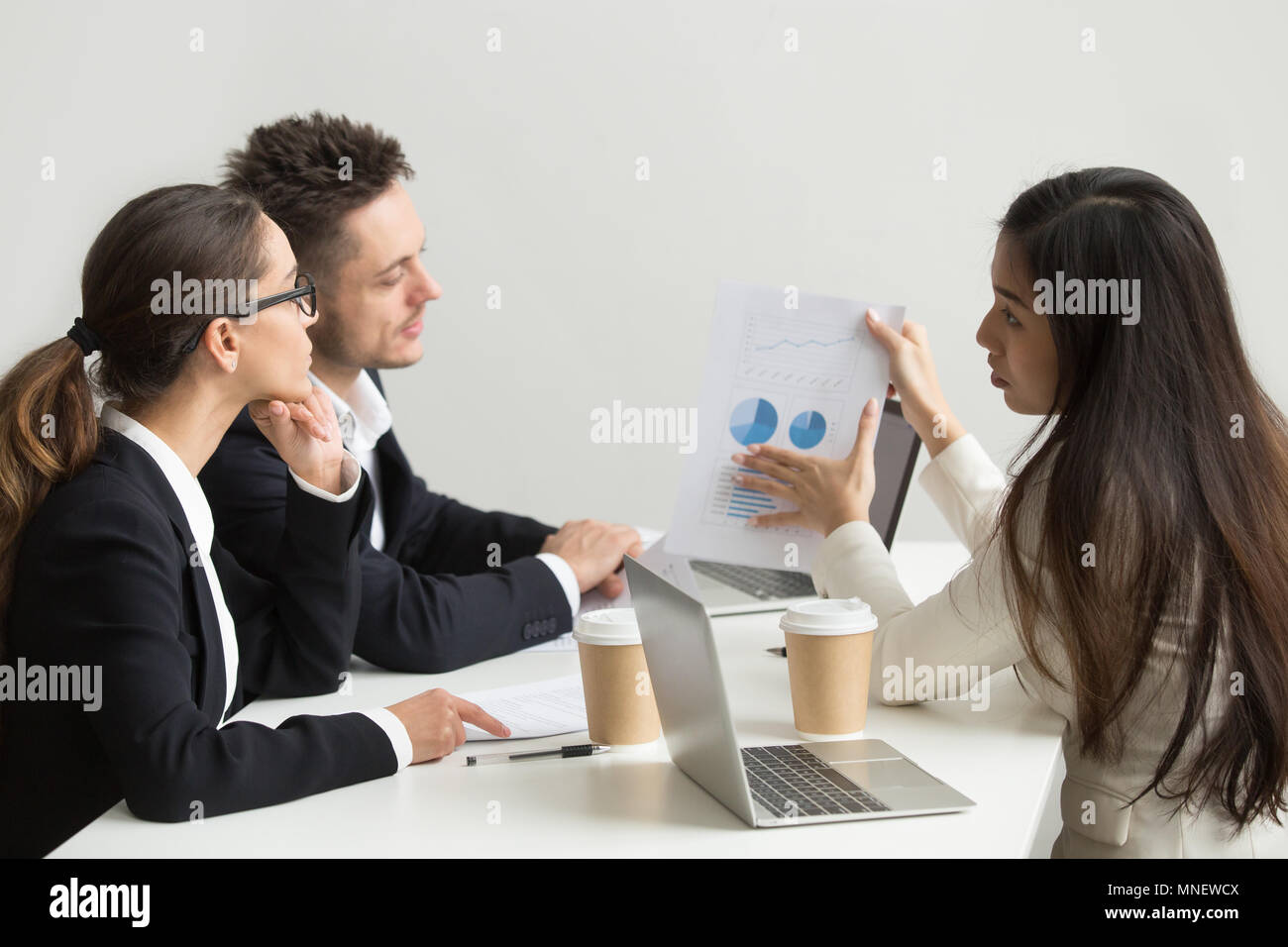 Female worker presenting visual templates to coworkers Stock Photo - Alamy