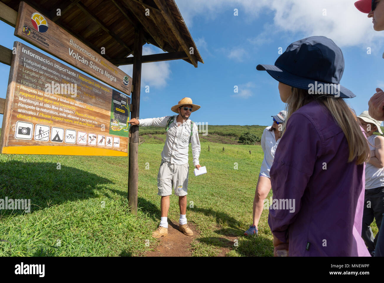Naturalist guide giving a talk at an interpretive sign at Sierra Negra ...