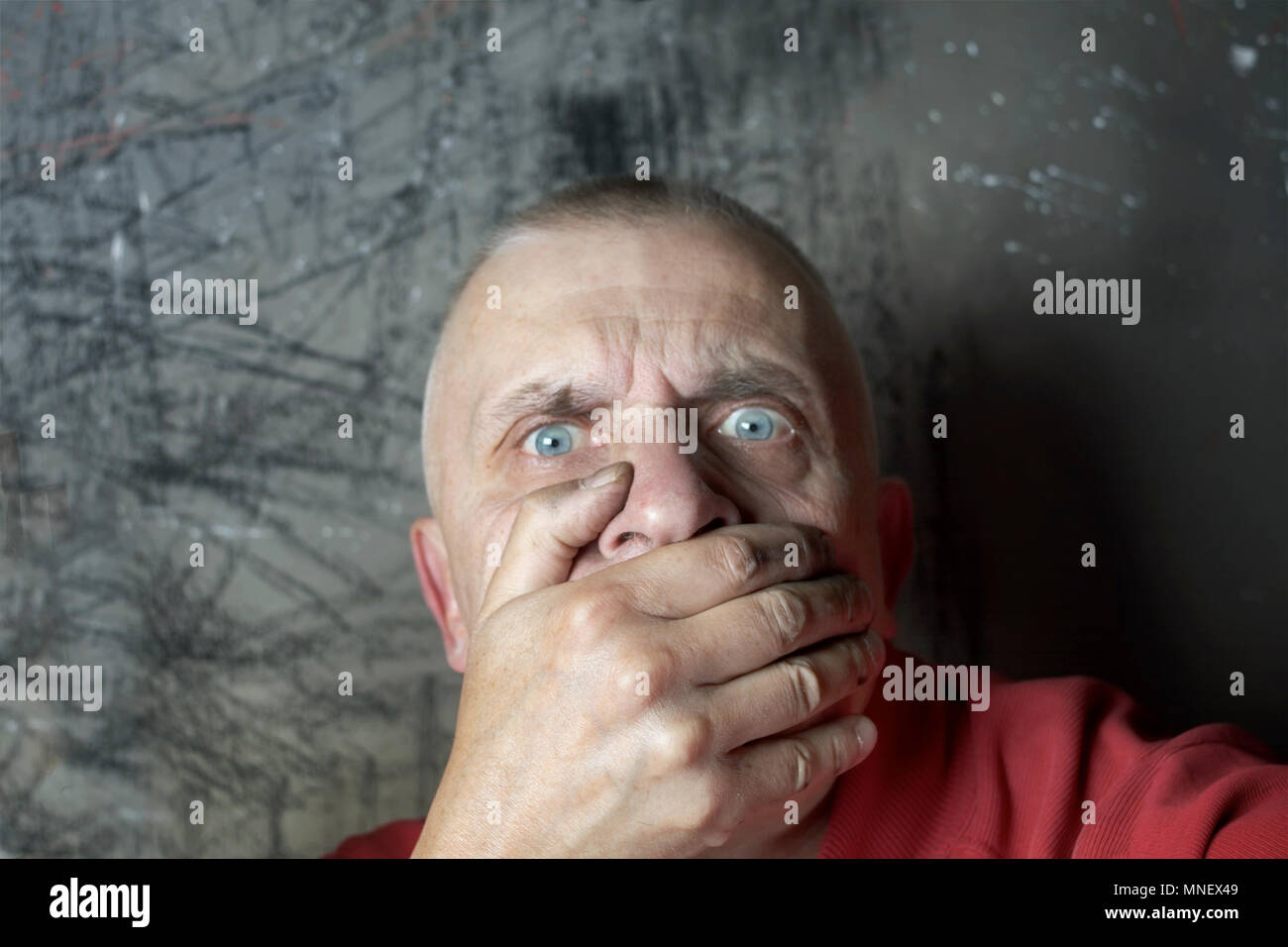 Scared man covering his face in shock, studio portrait Stock Photo - Alamy
