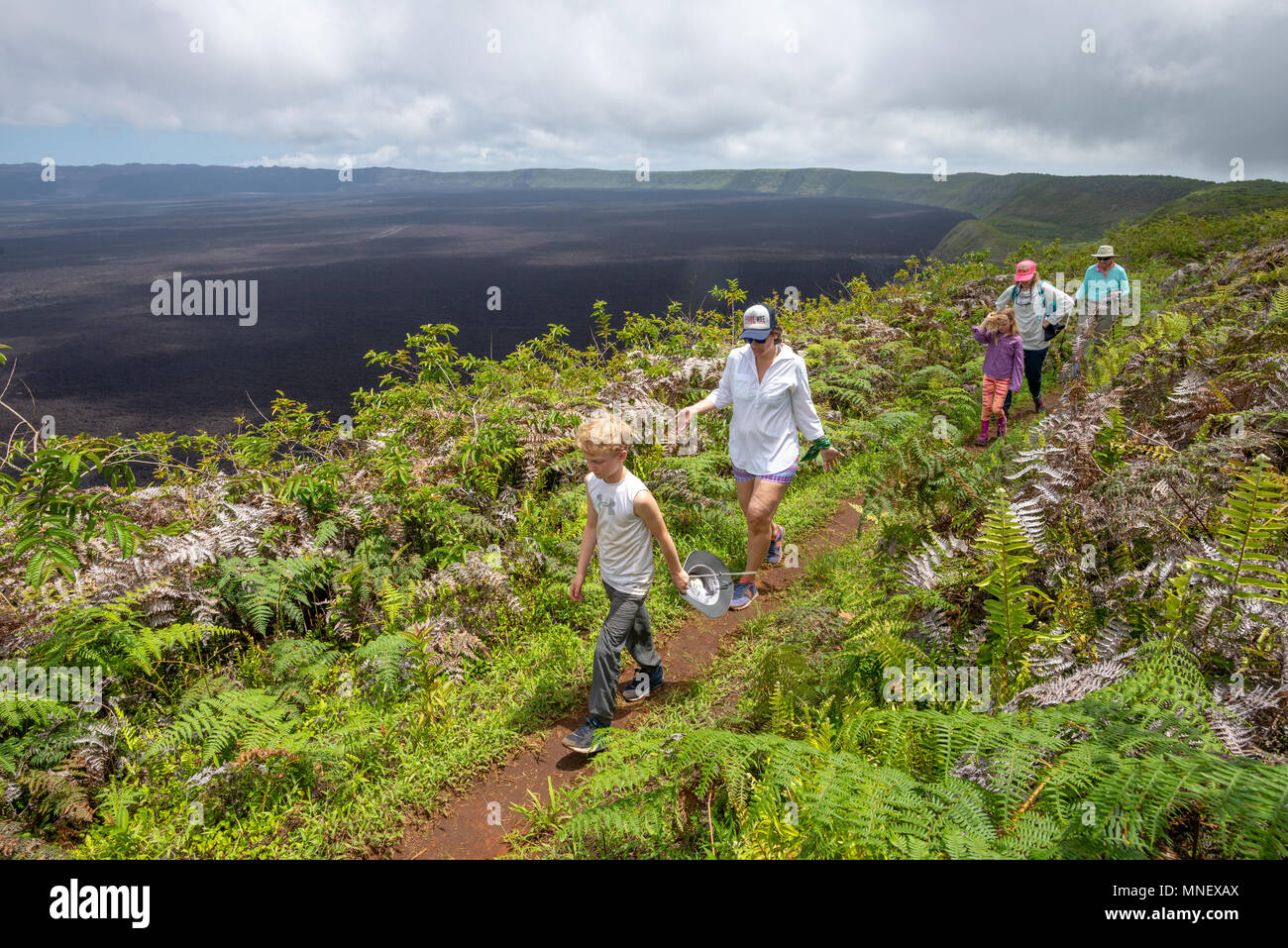 Group hiking along the rim of the Sierra Negra volcano, Isabela Island ...
