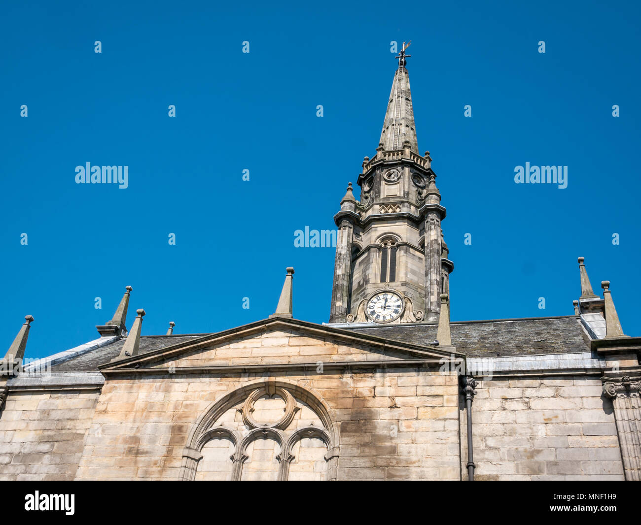 Looking up at Tron Kirk, Hunter Square, with spire against blue sky ...