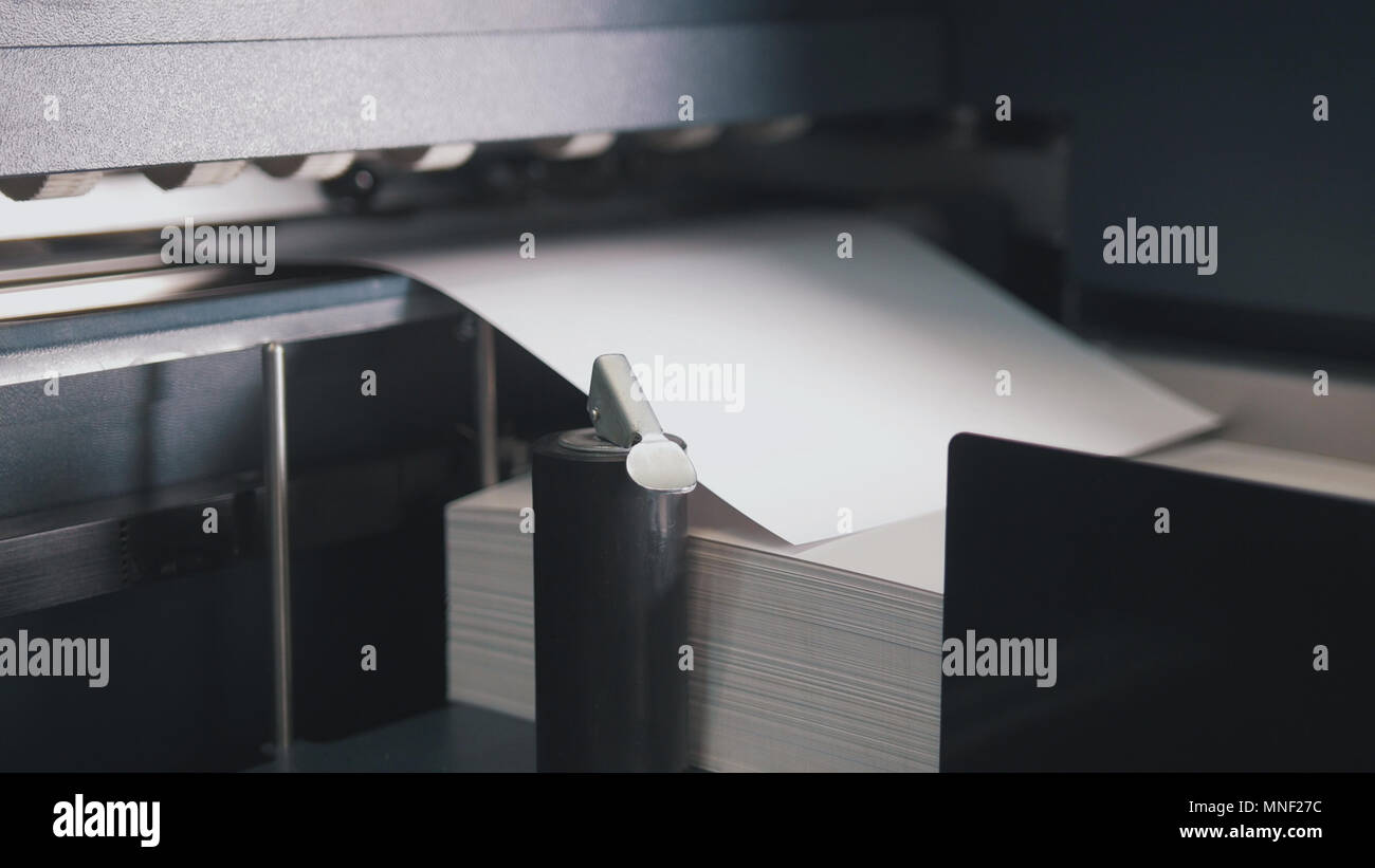 Printing press machine takes sheet of paper in action in the printing ...