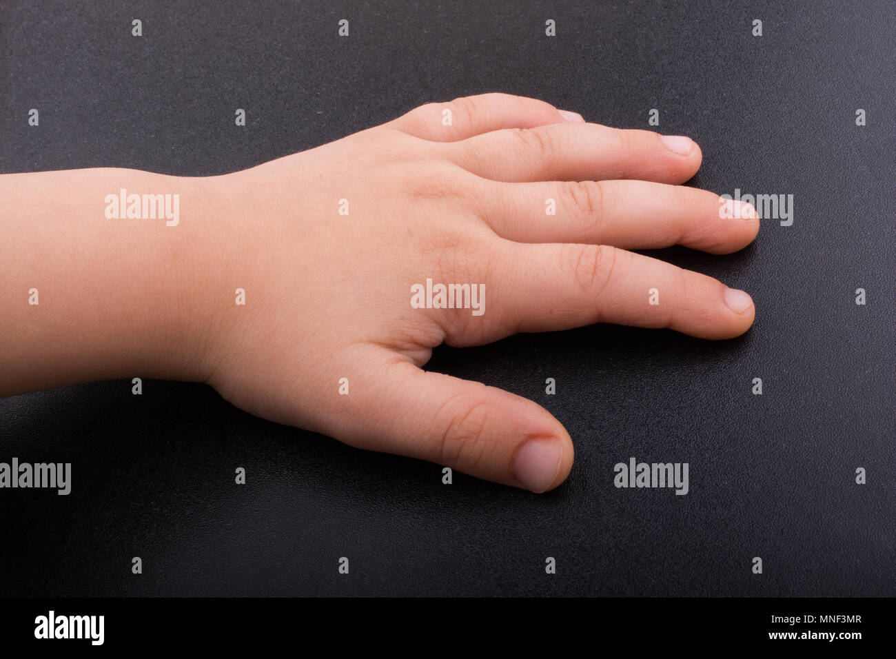 Toddler hand with dark color background Stock Photo - Alamy