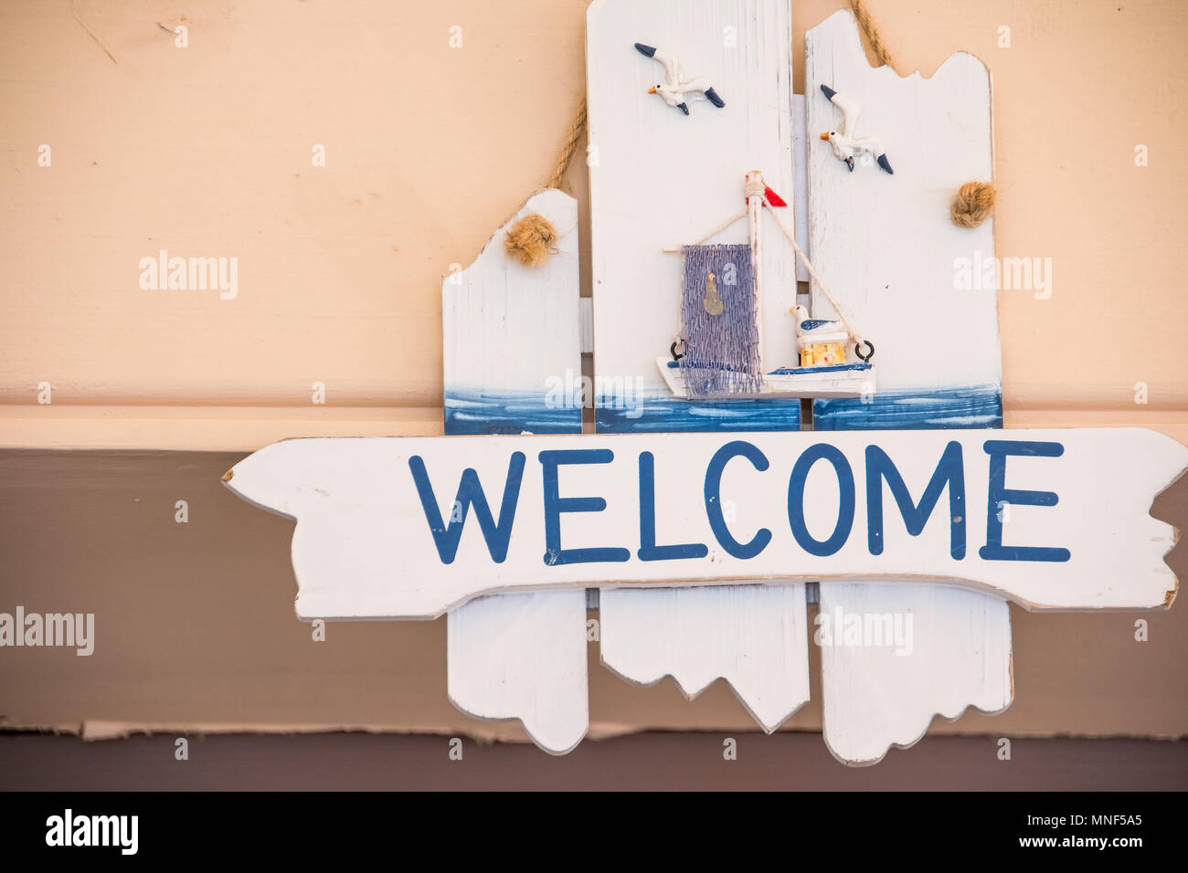 Wood welcome sign hanging on rustic wooden background. Marine theme ...