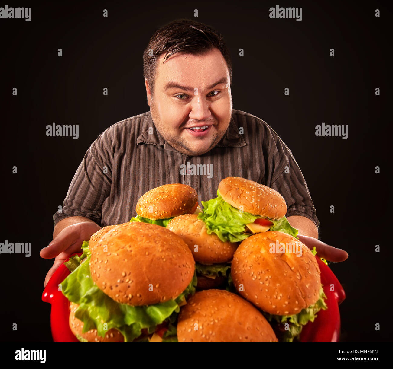 Fat man eating fast food hamberger. Breakfast for overweight person ...